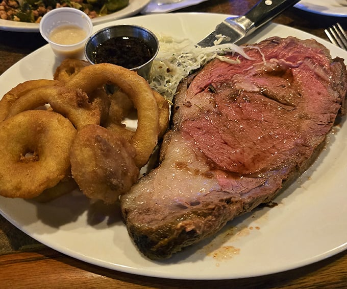 The prime rib arrives like a carnivore's dream—perfectly pink, accompanied by golden onion rings that shatter with satisfying crispness. This is meat worth writing home about.