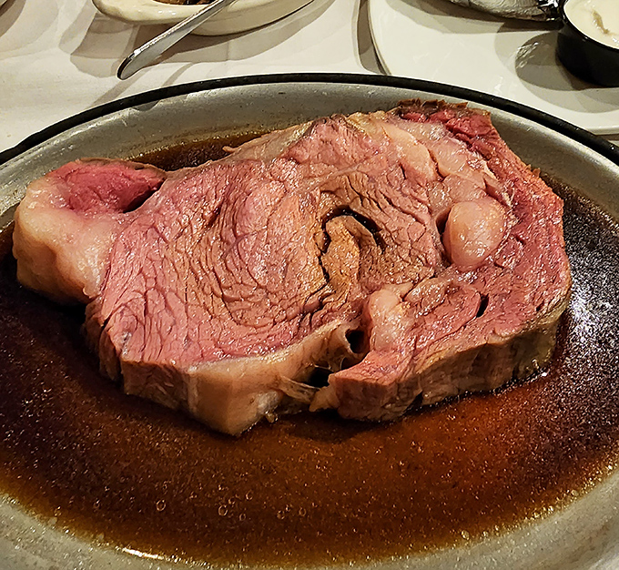 This isn't just prime rib; it's a masterpiece of meat – perfectly pink, swimming in savory jus, waiting to make your taste buds dance.