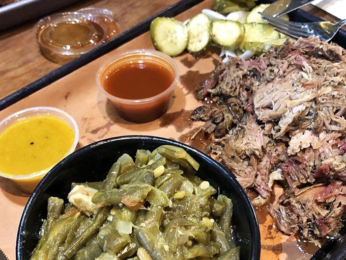 Green beans, pickles, and pulled pork sharing a tray – it's the barbecue equivalent of a perfect ensemble cast where every character gets their moment.