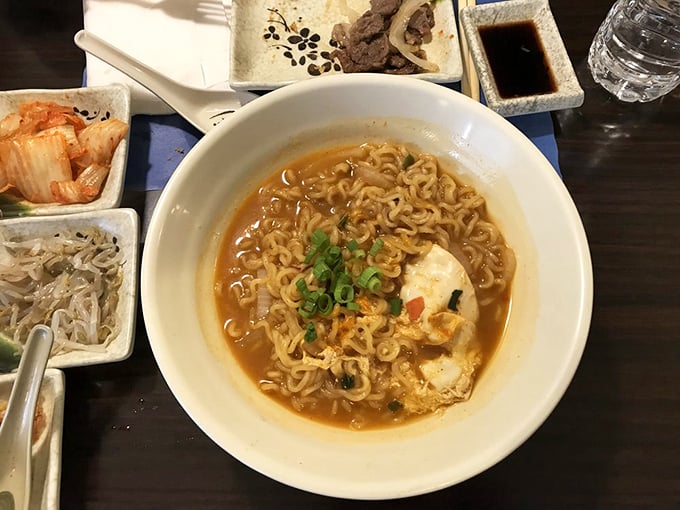 This isn't your college dorm ramen – it's a soul-warming bowl where curly noodles swim in broth that's been simmering longer than most TV shows run.