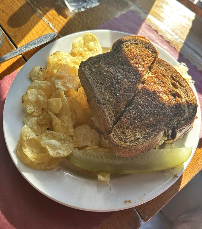 This isn't just a Reuben sandwich—it's architecture with purpose. Crispy edges, hearty filling, and chips that crunch loud enough to turn heads.