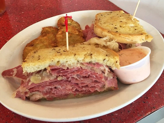 Behold the Reuben in all its glory—layers of corned beef stacked higher than a Nashville songwriter's ambitions, with sauerkraut and Swiss playing perfect harmony.