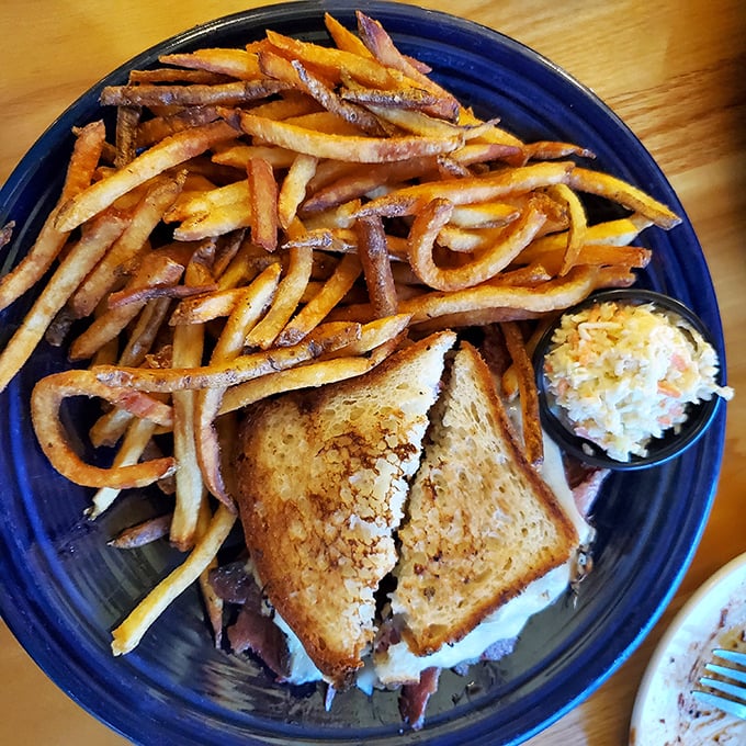 Behold the star attraction: a Reuben sandwich that doesn't just satisfy hunger—it creates memories, with golden fries standing by for supporting-actor duties.