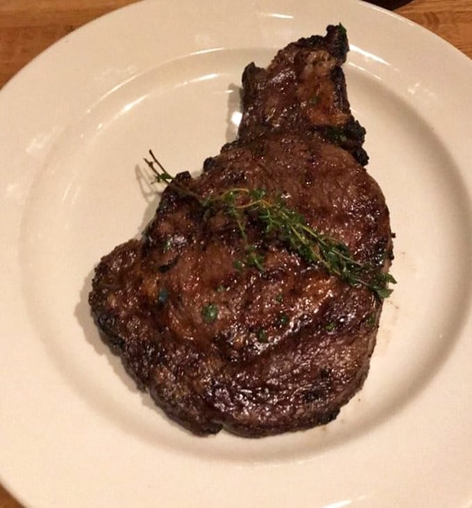 Behold the ribeye in all its glory – a perfect crust giving way to juicy tenderness. That sprig of thyme isn't garnish, it's a victory flag.