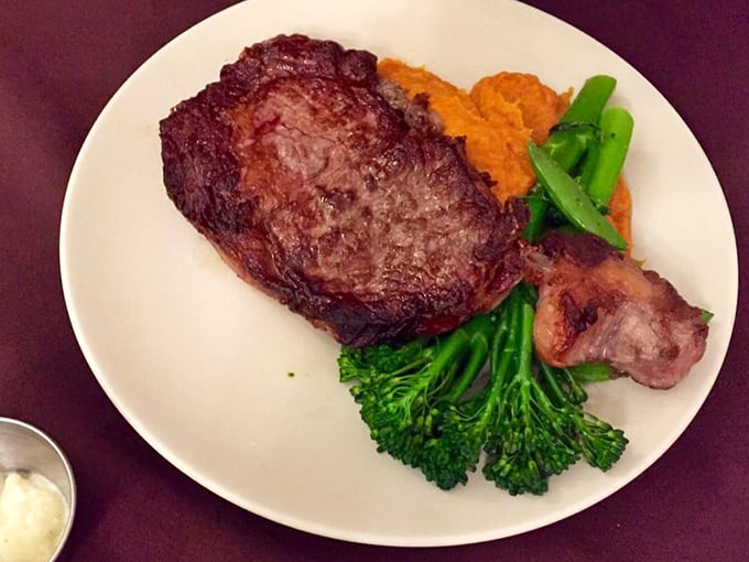This ribeye achieves what every steak dreams about – a perfect char outside, blushing pink perfection within.