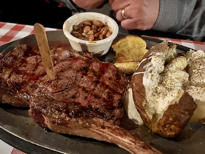 Behold the star of the show – a perfectly seared ribeye that could make a vegetarian question their life choices, served with a loaded baked potato that's practically a meal itself.