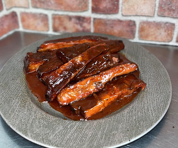 These ribs glisten with sauce like they're auditioning for a food magazine cover, but they're not here to look pretty—they're here to change your life.