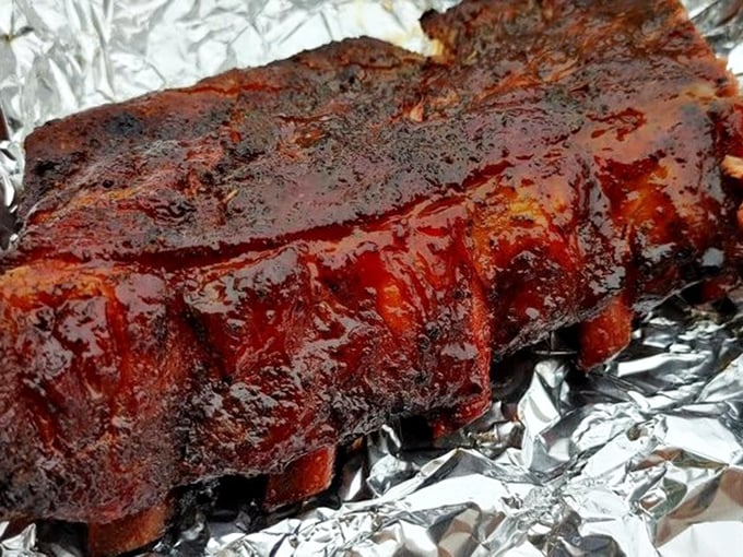 These ribs don't just fall off the bone—they practically leap with joy after their 14-hour smoke bath in apple and cherry wood.