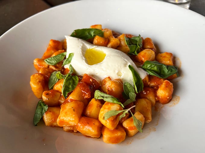 Cloud-like pillows of ricotta gnocchi swimming in tomato sugo with fresh basil—proof that heaven exists and it's made of cheese.