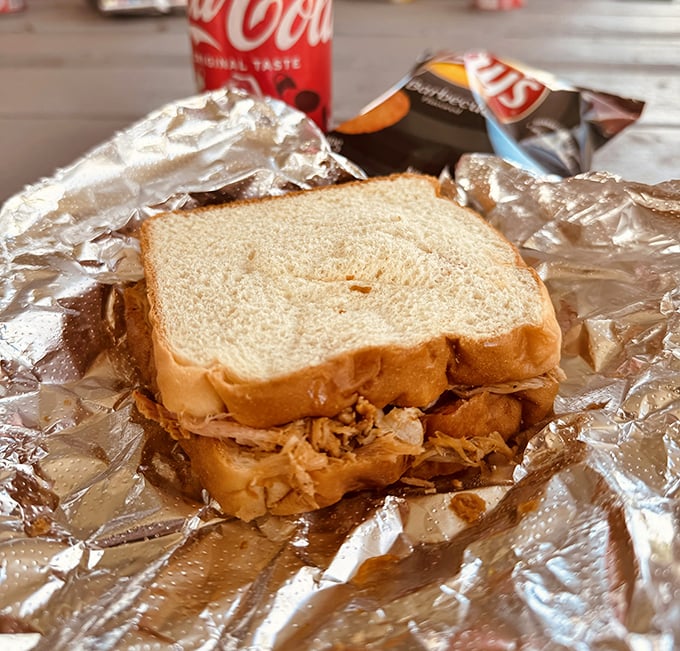 Behold barbecue in its purest form – tender smoked pork nestled between slices of white bread, a sandwich so honest it makes fast food weep with shame.