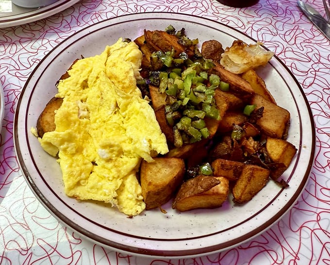 Sunshine-yellow scrambled eggs nestle against golden home fries with green peppers—a plate that says "good morning" better than words ever could.
