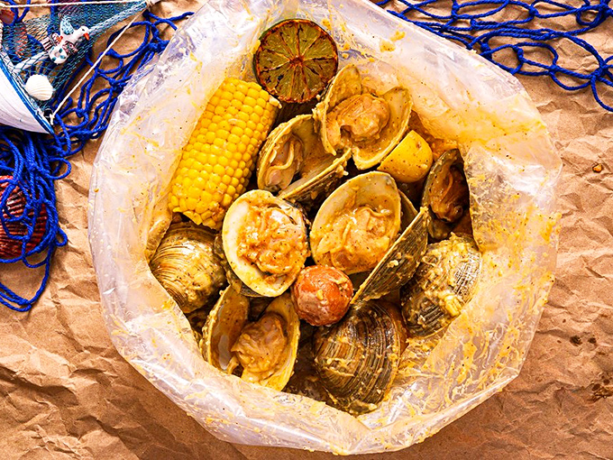 Seafood boils arrive like edible presents—clear bags bursting with clams, corn, and potatoes swimming in sauce that's worth every napkin you'll need.