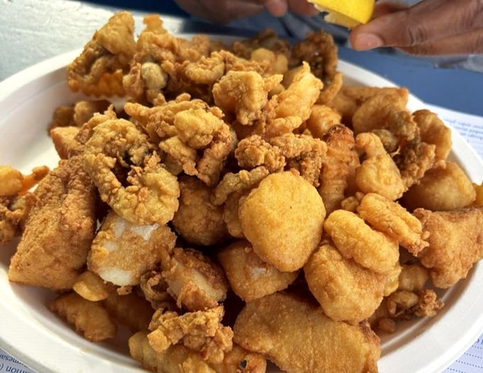 Golden-fried seafood piled high on a plate—this isn't just food, it's edible sunshine that crunches between your teeth and tastes like vacation.