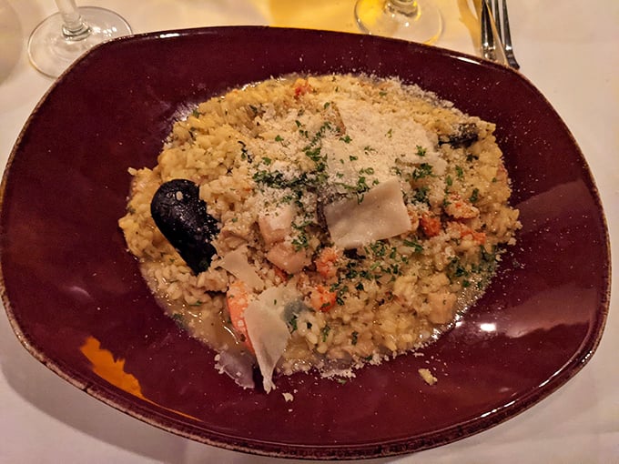 The legendary seafood risotto arrives like edible artwork—creamy rice cradling treasures from the sea, finished with a snowfall of Parmesan. Worth every calorie.