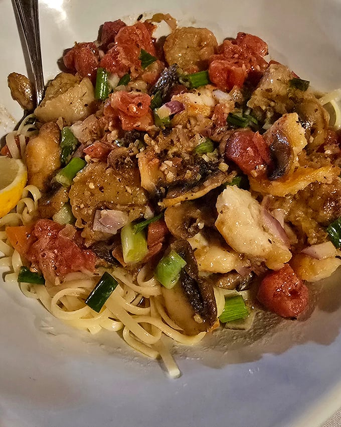 Seafood Scampi that would make Neptune himself weep – plump shrimp, tender scallops, and lobster dancing atop perfectly cooked linguine.