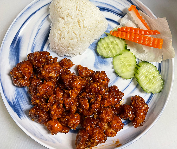 Glossy, sesame-studded chicken sitting beside perfectly steamed rice—this is the dish that launched a thousand road trips across South Carolina.