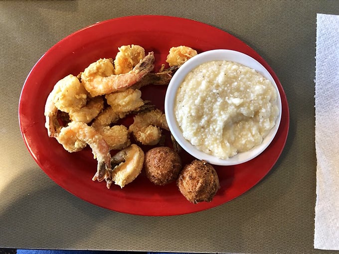 Golden-fried shrimp nestled beside creamy grits and hush puppies—a trio so perfect together they should form a band.