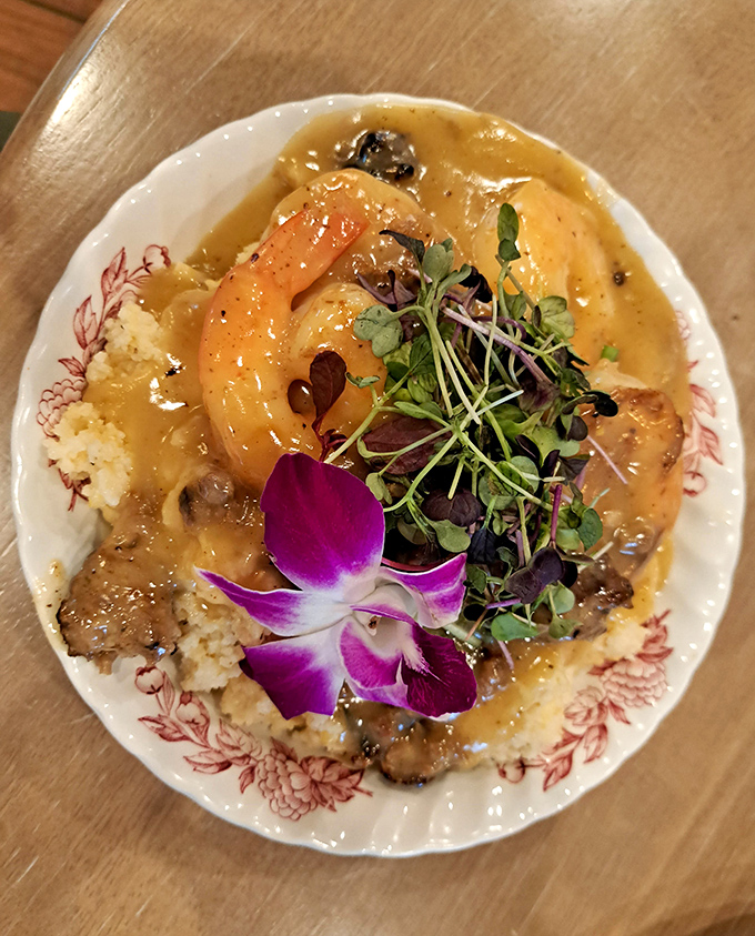 Shrimp and grits that would make a Southerner weep with joy. The purple orchid isn't just garnish—it's nature's way of applauding this dish.