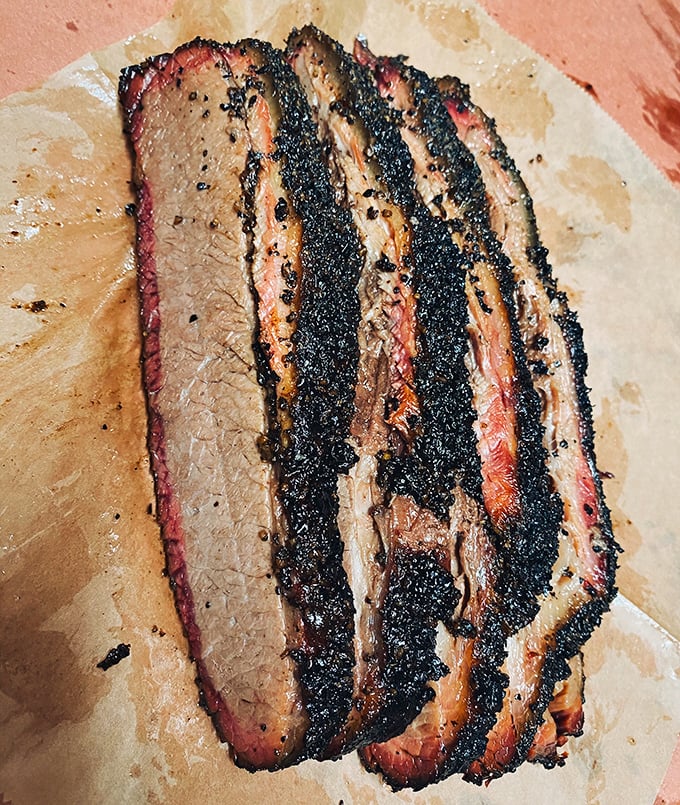 Brisket slices that could make a Texan weep with joy. That bark, that smoke ring, that tenderness—it's the holy trinity of barbecue perfection.