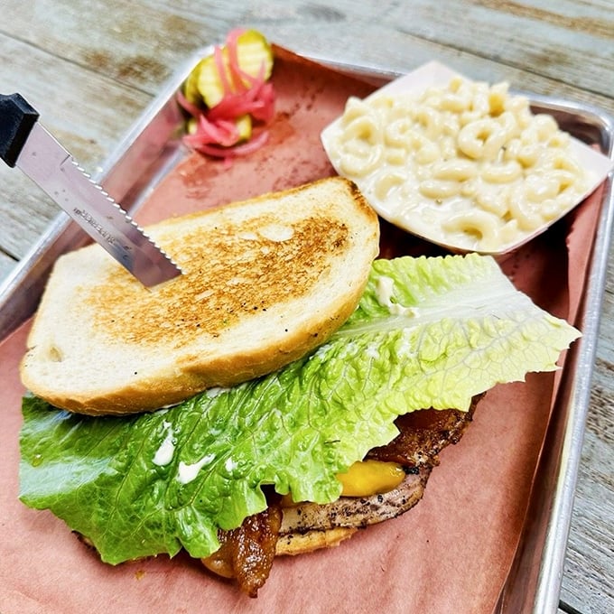 The legendary smoked turkey club arrives like a delicious architectural achievement—layers of house-smoked turkey, crisp lettuce, and toasted bread with mac and cheese standing guard.