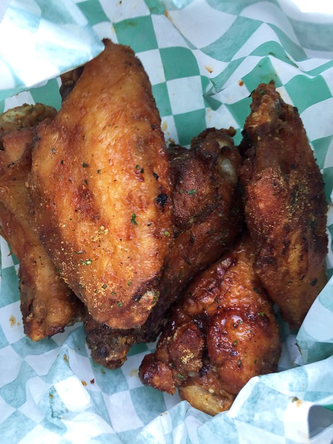 These aren't just wings; they're smoke-kissed masterpieces with a crispy exterior that shatters like childhood dreams when your parents said "we'll see."