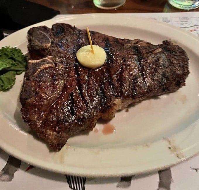 Behold the T-bone in its natural habitat – gloriously charred exterior, perfectly pink interior, and a pat of butter melting like a summer snowflake.