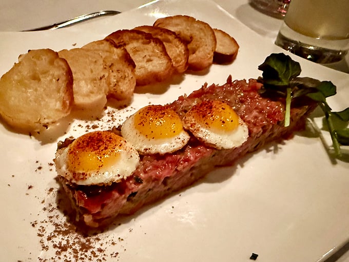 Steak tartare with quail eggs perched atop like tiny sentinels guarding a treasure of perfectly seasoned raw beef—culinary daring at its finest.