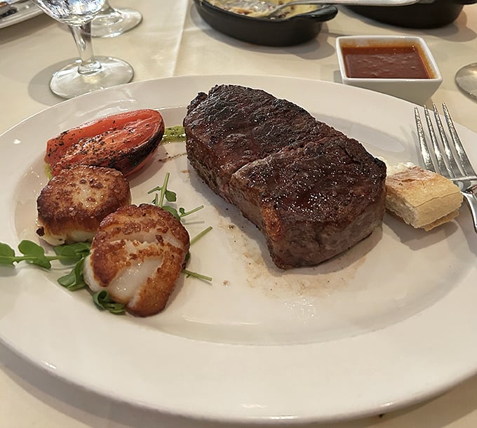 Perfection on a plate: a steak with the kind of sear that makes you want to applaud, alongside scallops that taste like butter's sophisticated cousin.