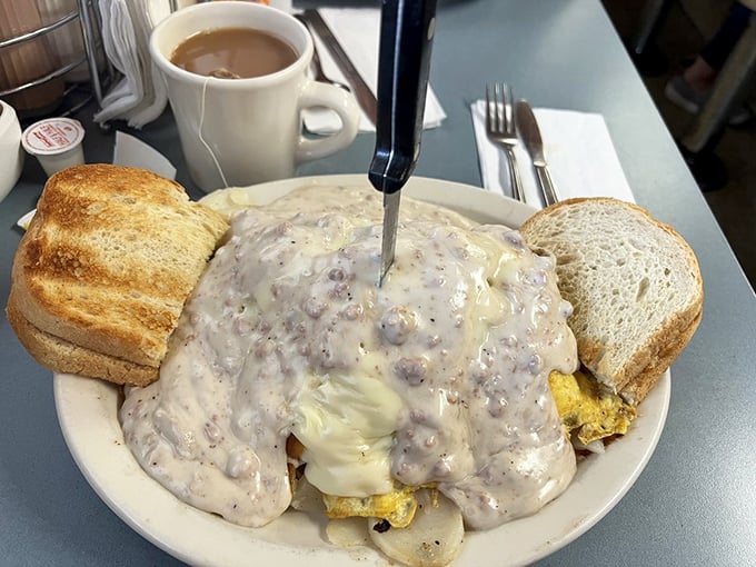 Behold the holy grail of breakfast engineering—creamy sausage gravy cascading over golden hash browns and eggs. Napkins required, regrets impossible.