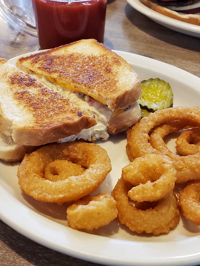Behold the legendary tuna melt in all its glory—perfectly grilled bread, melty cheese, and a pickle spear that knows its supporting role.