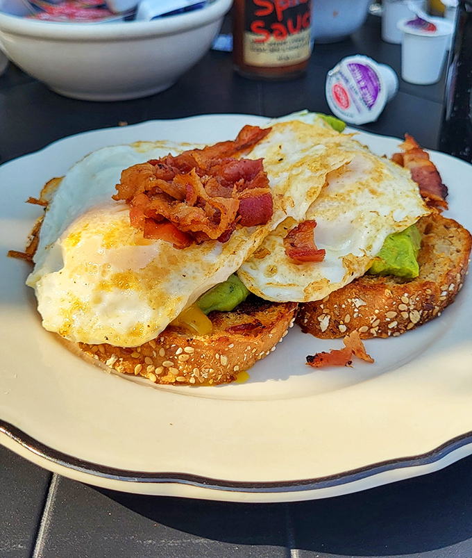 Avocado toast gets the diner treatment—eggs your way, crumbled bacon, and enough guacamole to make millennials weep with joy.
