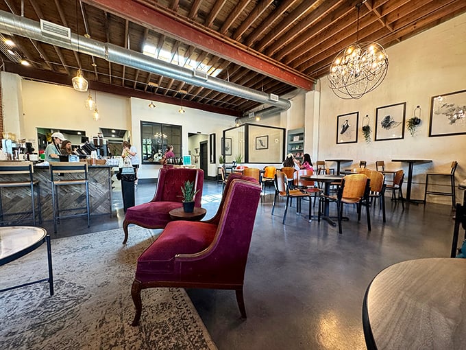 Exposed beams, elegant chandeliers, and those burgundy chairs that practically whisper "stay awhile"—this coffee shop understands the art of ambiance.