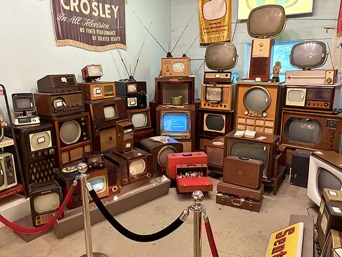 Television history stacked floor-to-ceiling—from wooden console Crosleys to Space Age portables, each one broadcasting memories from decades past.