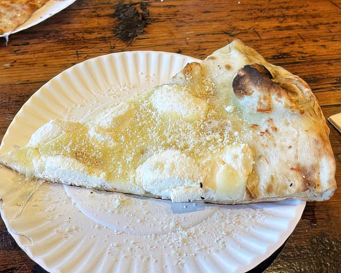 The white pizza – a canvas of creamy indulgence that proves sometimes the absence of red sauce creates a masterpiece all its own.