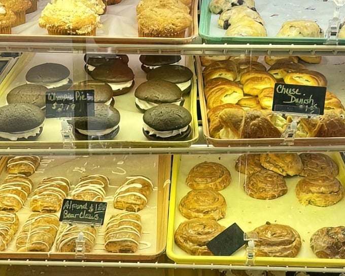 The display case reveals the star attraction—chocolate whoopie pies nestled alongside cheese danish and bear claws, a trifecta of temptation few can resist.
