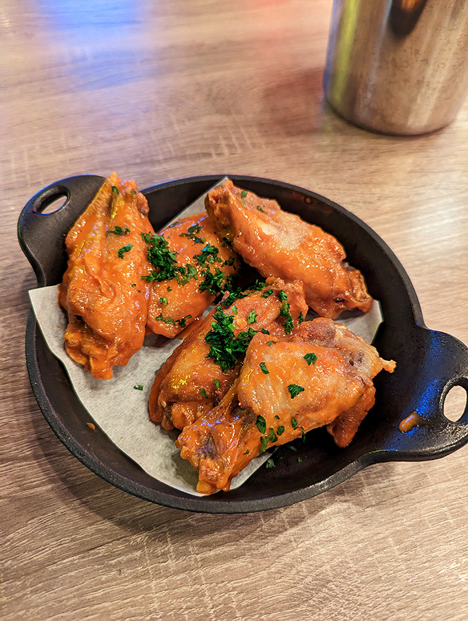 These wings aren't just cooked—they're transformed. Glistening with sauce and garnished with herbs, they're the reason napkins were invented.