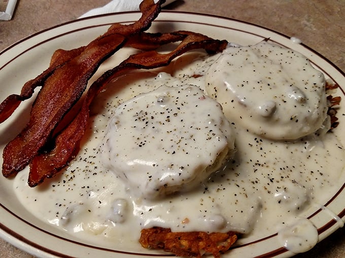 Behold: biscuits and gravy nirvana. Those pepper-flecked pools of creamy gravy embrace homemade biscuits while crispy bacon stands guard. Breakfast perfection exists!