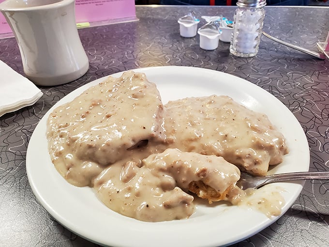 Biscuits swimming in creamy sausage gravy – this plate doesn't care about your diet plans or your arteries, just your immediate happiness.