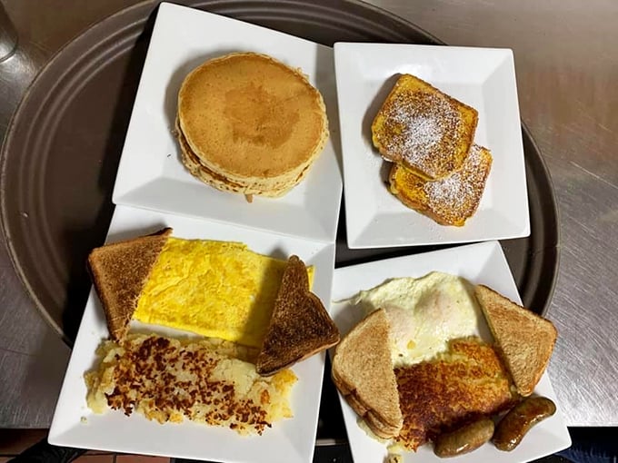 Breakfast perfection on a plate—golden pancakes, French toast dusted with powdered sugar, eggs with hash browns, and sausage links standing at attention.