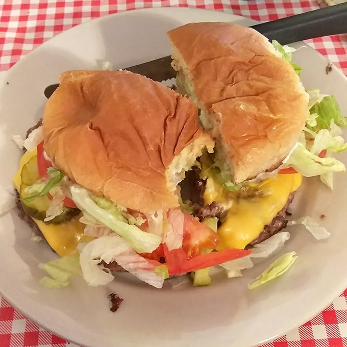 Behold the star attraction: a burger that requires strategic planning to eat. That melty cheese cascade isn't just delicious—it's edible architecture.