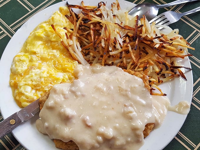 Breakfast nirvana: golden scrambled eggs, crispy hash browns, and that gravy-smothered biscuit. A holy trinity of morning deliciousness that demands a moment of silence.