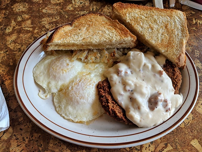Country fried steak smothered in peppery gravy alongside sunny-side-up eggs—the breakfast equivalent of finding an extra $20 in your winter coat pocket.