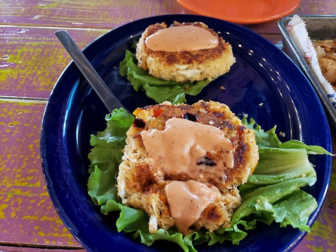 Golden-brown crab cakes perched on crisp lettuce—where sweet lump crabmeat meets a perfectly seasoned crust in seafood harmony.