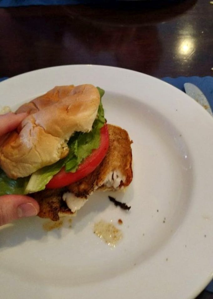 The legendary grouper sandwich in all its glory—perfectly golden, nestled between a pillowy bun with fresh veggies. Worth crossing county lines for.