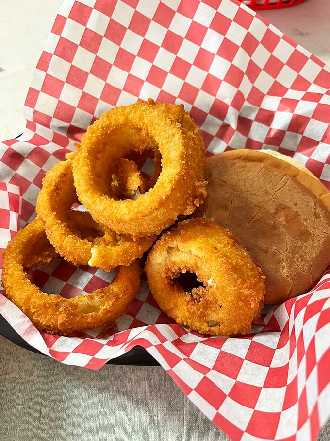 Golden-brown onion rings with the perfect crunch-to-tenderness ratio, served with a pillowy bun—proof that simplicity, when done right, is culinary poetry.