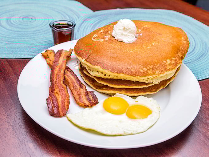 Pancake perfection isn't complicated—golden discs of fluffy joy, crispy bacon, and sunny-side eggs create the breakfast holy trinity.