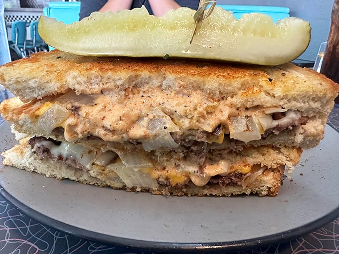 This isn't just a sandwich; it's structural engineering with melted cheese. The patty melt arrives with a pickle spear standing guard like a delicious sentinel.
