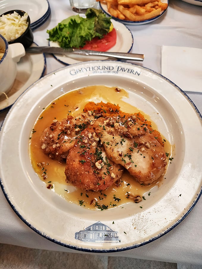 This pecan-crusted chicken swimming in buttery sauce isn't just dinner—it's edible proof that sometimes the best things in life require a napkin tucked into your collar. 