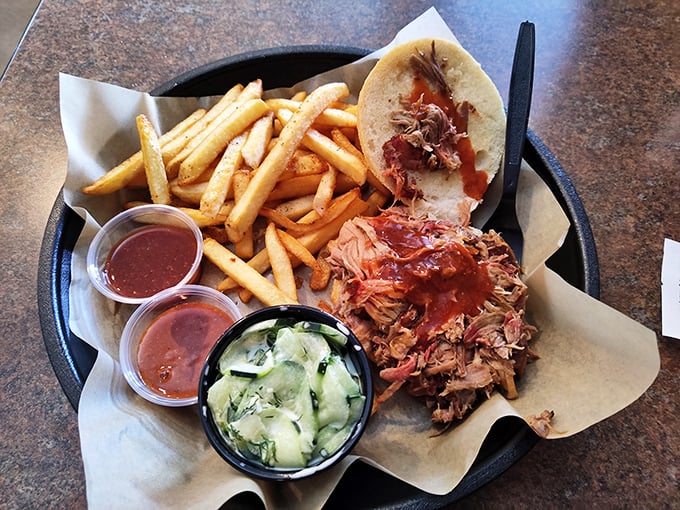 Pulled pork paradise on a platter, with enough sauce options to make your taste buds dance.