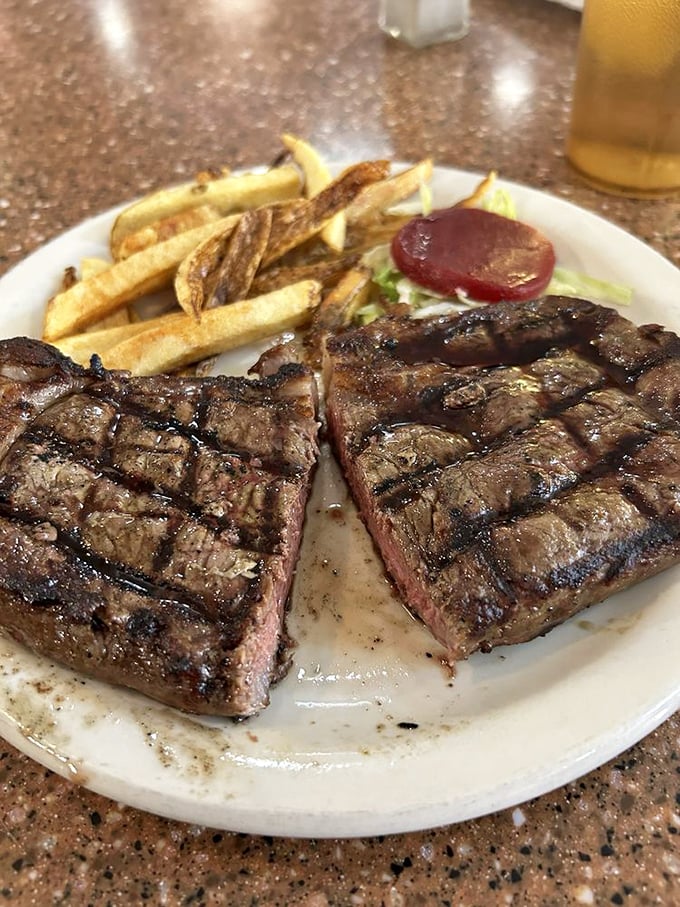 This isn't just steak – it's a masterclass in meat. Ray's ribeye arrives with perfect grill marks and fries that could make a potato proud.